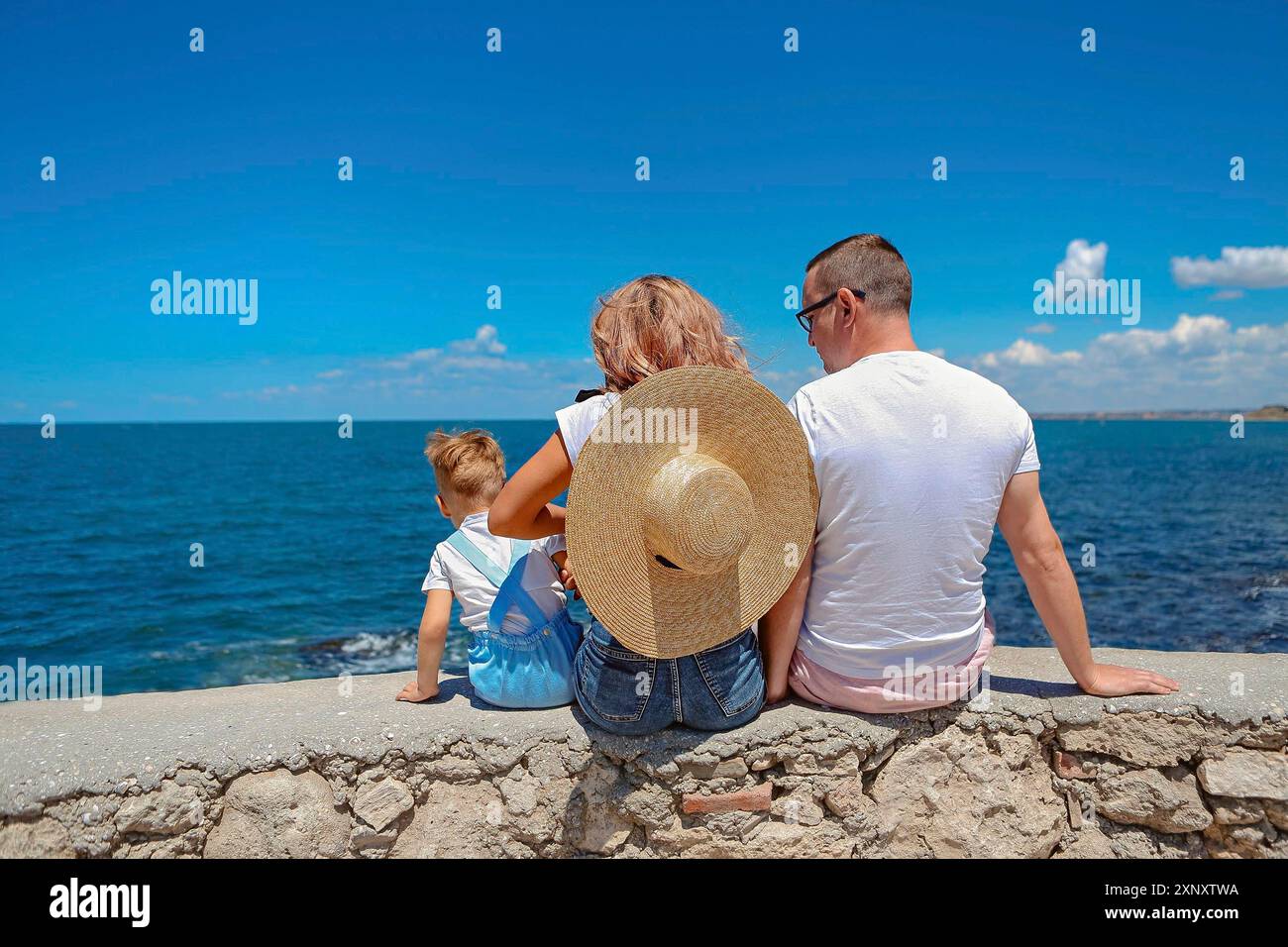 Back view of faceless mother father and little son in casual wear ...