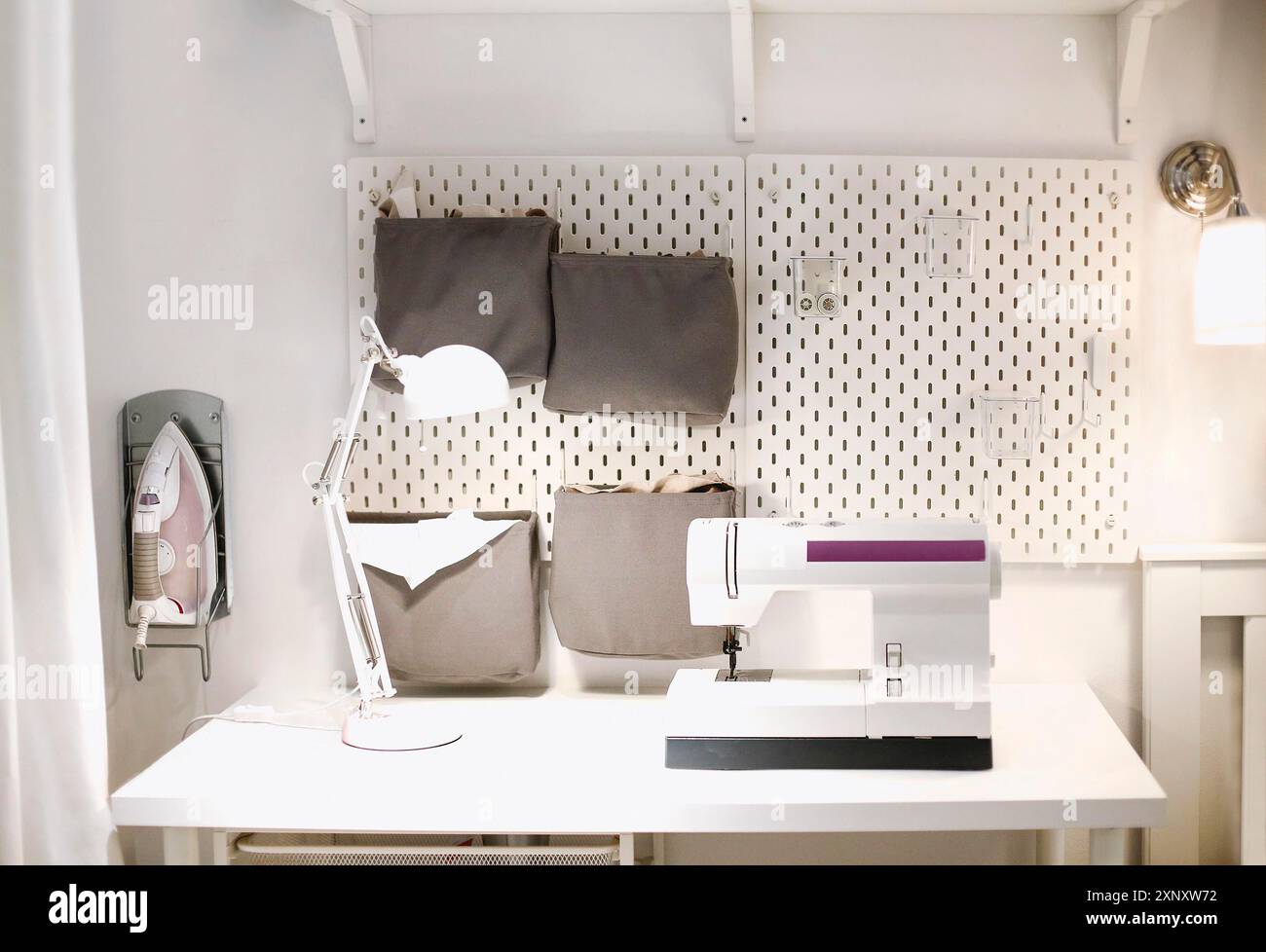 Sewing machine on table in tailor workshop. Workplace with lamp and ...