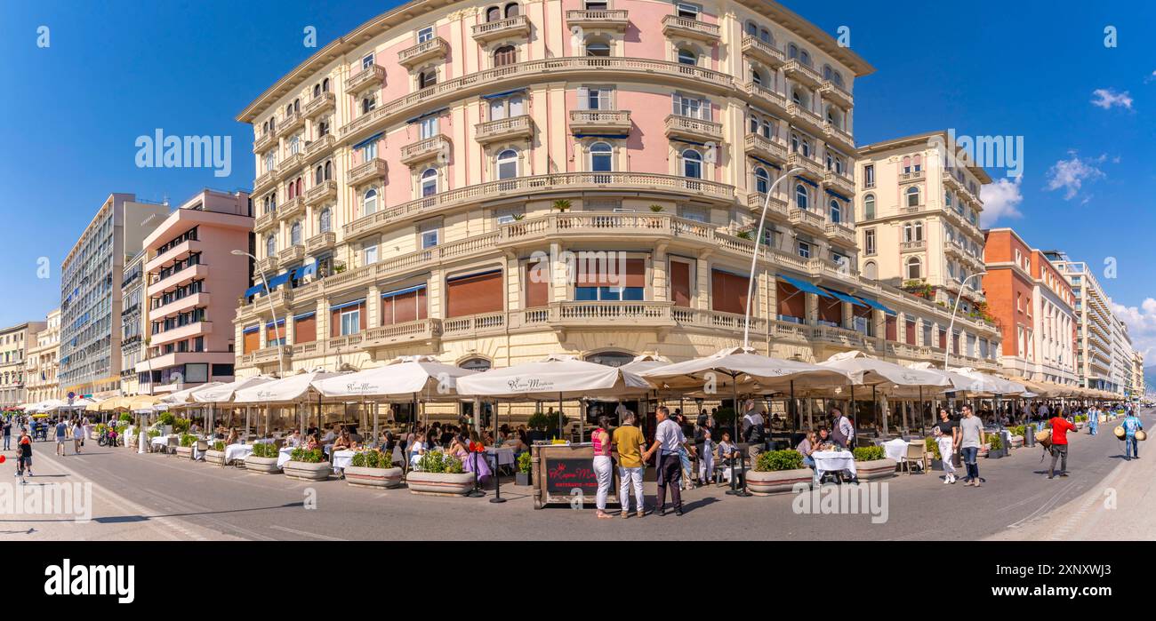 View of pastel coloured architecture, restaurants and cafes on seafront ...