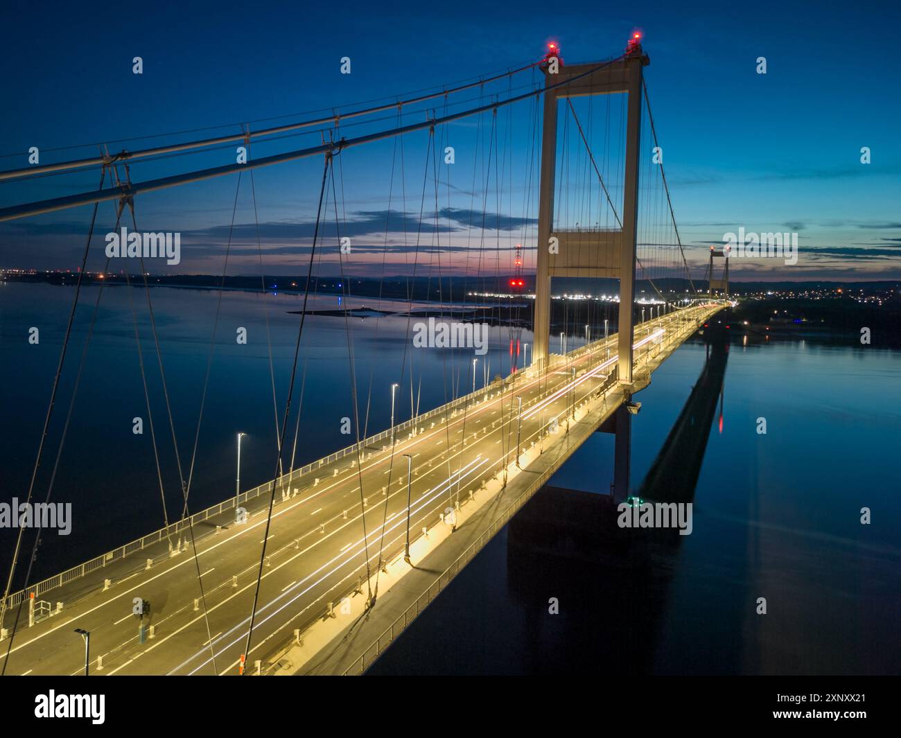 Suspension bridge connecting two cities, with its road illuminated by ...