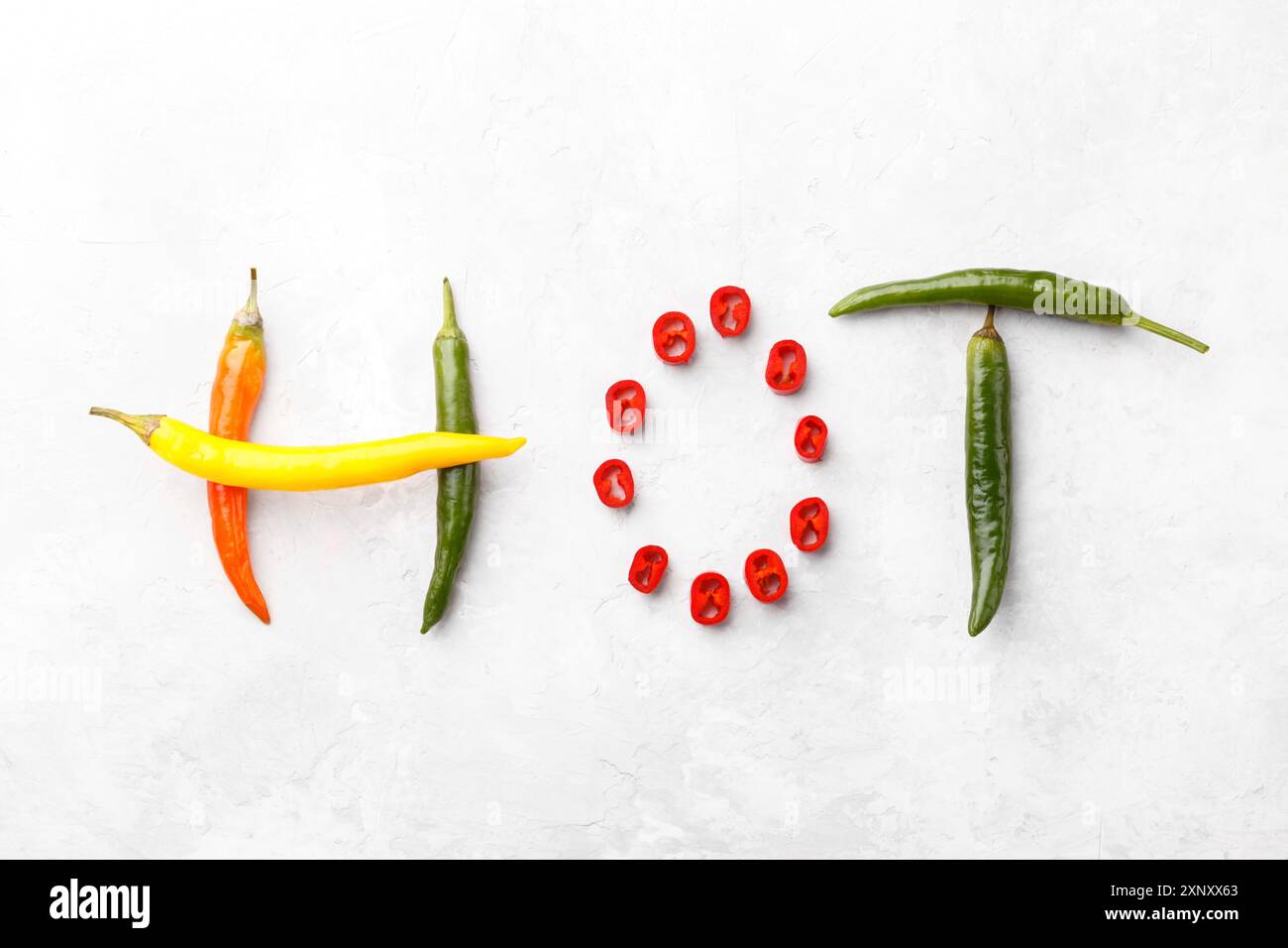 Word Hot made of red green and yellow chili peppers on grey stone ...