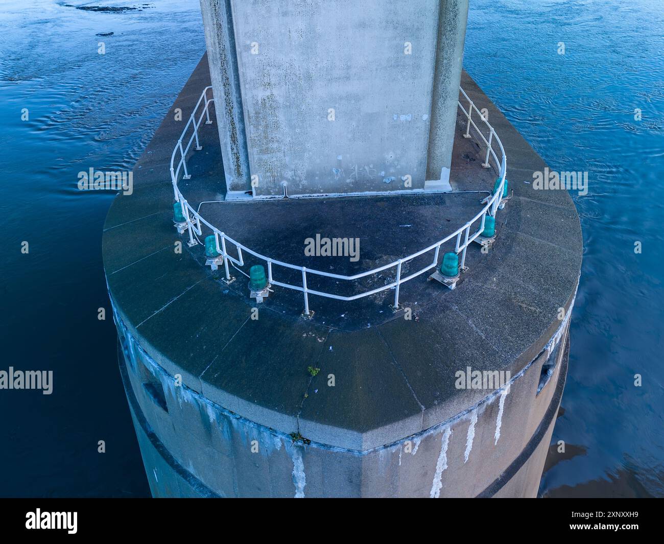 Concrete bridge pylon with green navigation lights is withstanding the ...