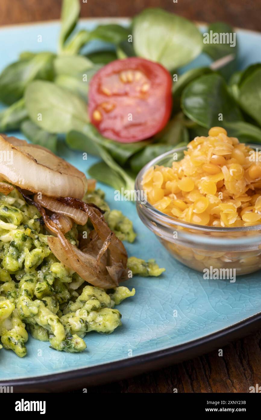 Spinach spaetzle on a blue plate Stock Photo - Alamy