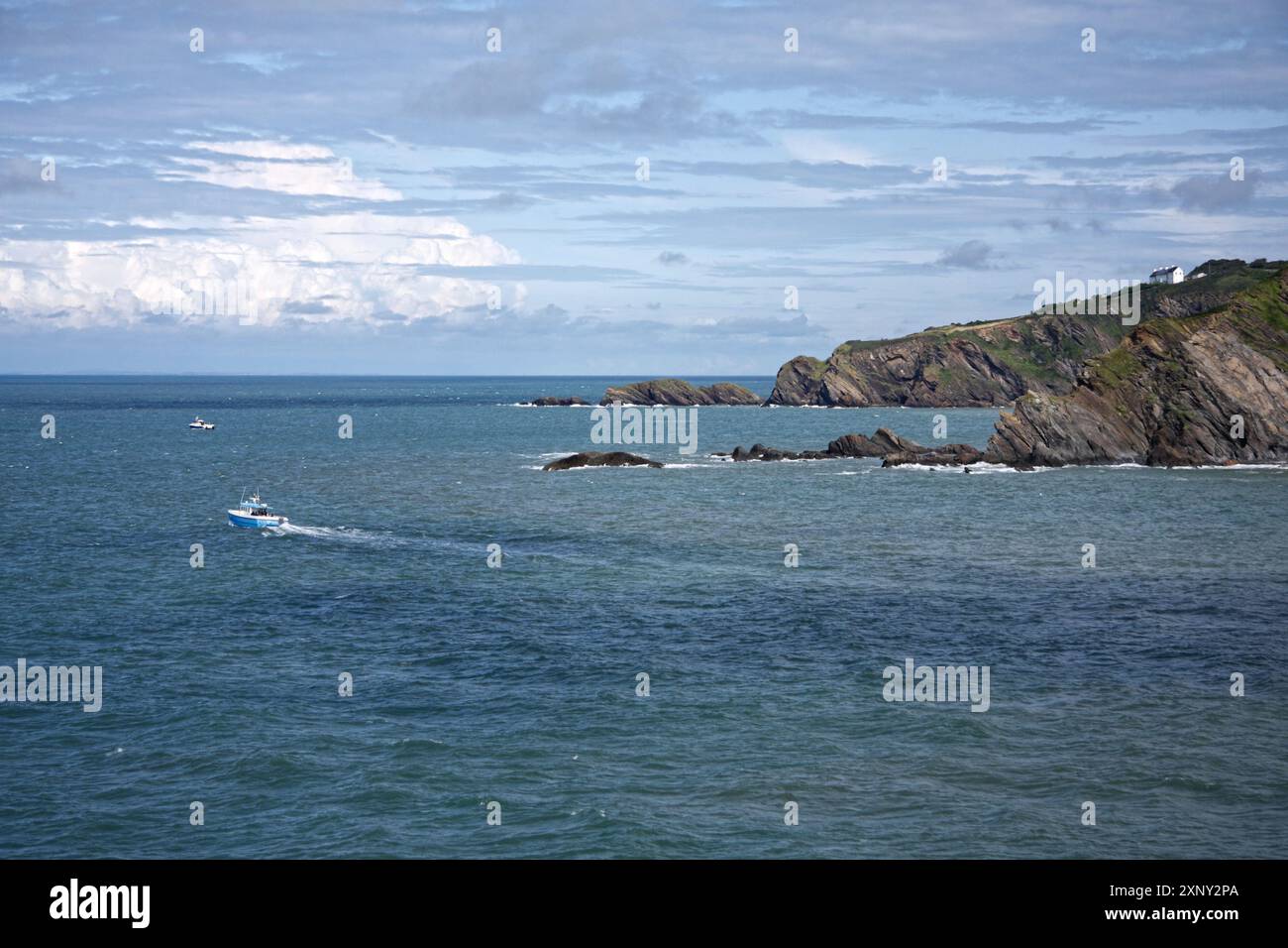 Tourist boat in British seaside bay sailing out to sea off Ilfracombe ...