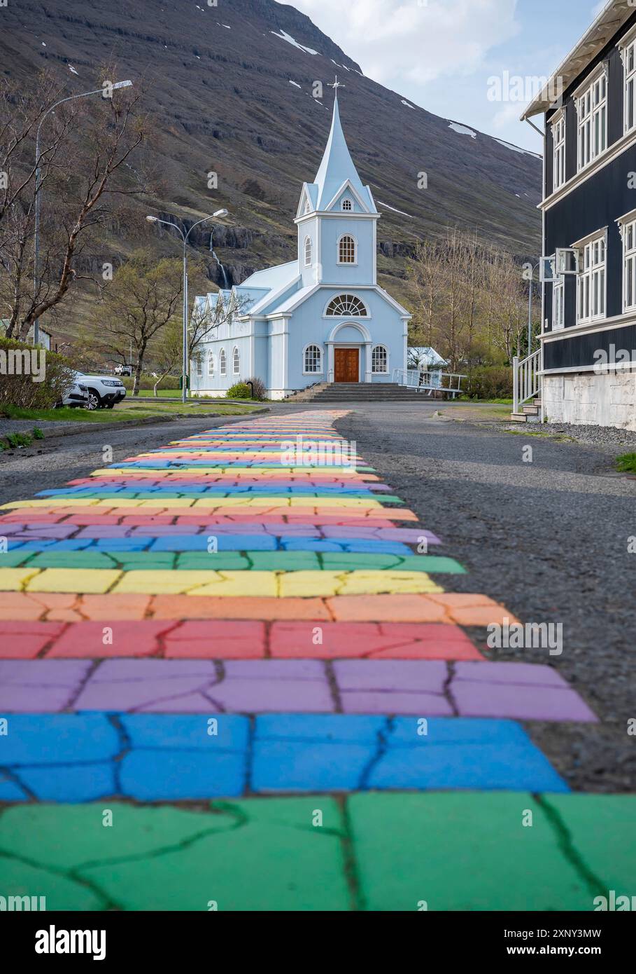 Church with Rainbow Road at Seydisfjordur, Iceland, view from low angle ...