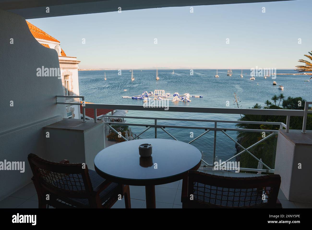 Serene Balcony View Overlooking Calm Sea with Sailboats and Water Park ...