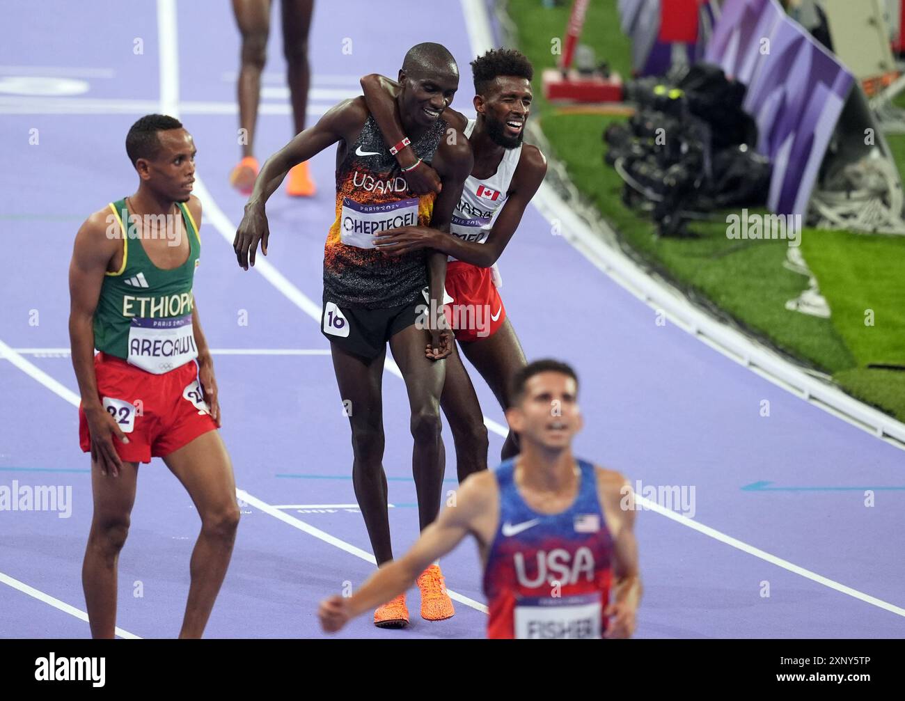 Uganda's Joshua Cheptegei with Canada's Mohammed Ahmed after winning ...
