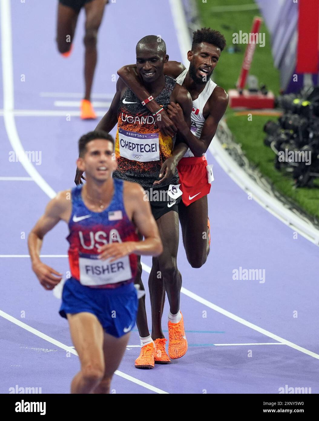 Uganda's Joshua Cheptegei with Canada's Mohammed Ahmed after winning ...