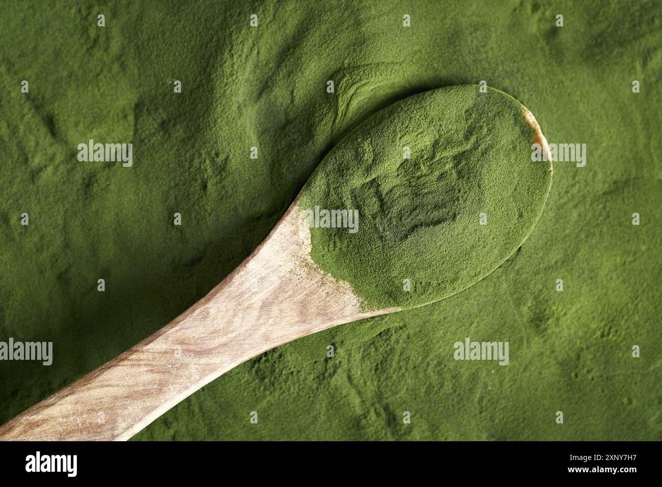 Green chlorella algae powder on a spoon, top view. Healthy nutritional ...