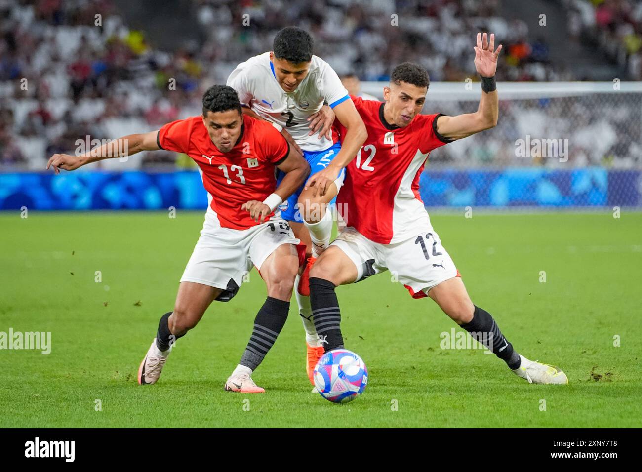 Paraguay's Alan Nunez, center, is fouled by Egypt's Karim El Debes ...