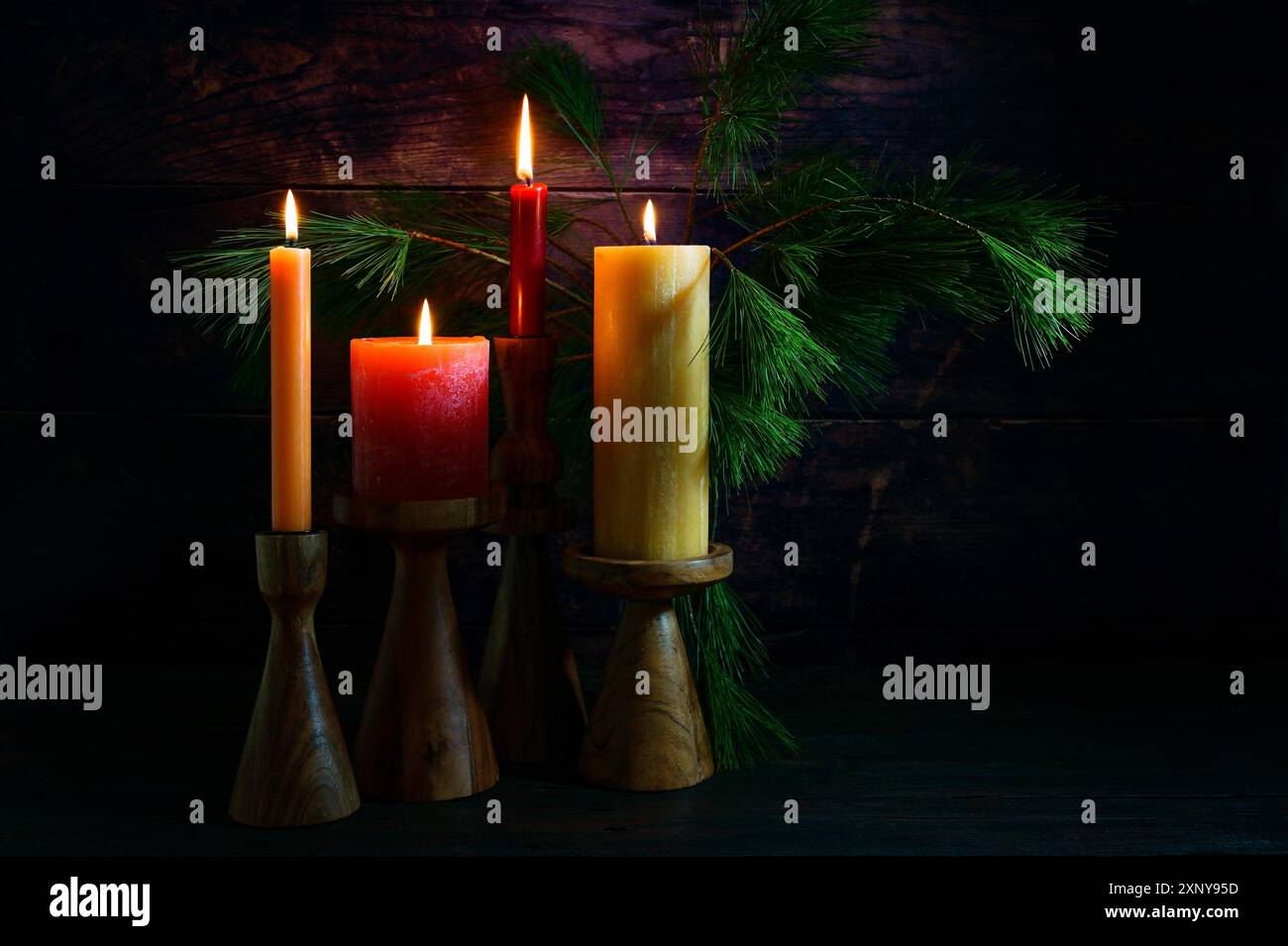 Advent arrangement with four candles in red and yellow on wooden ...