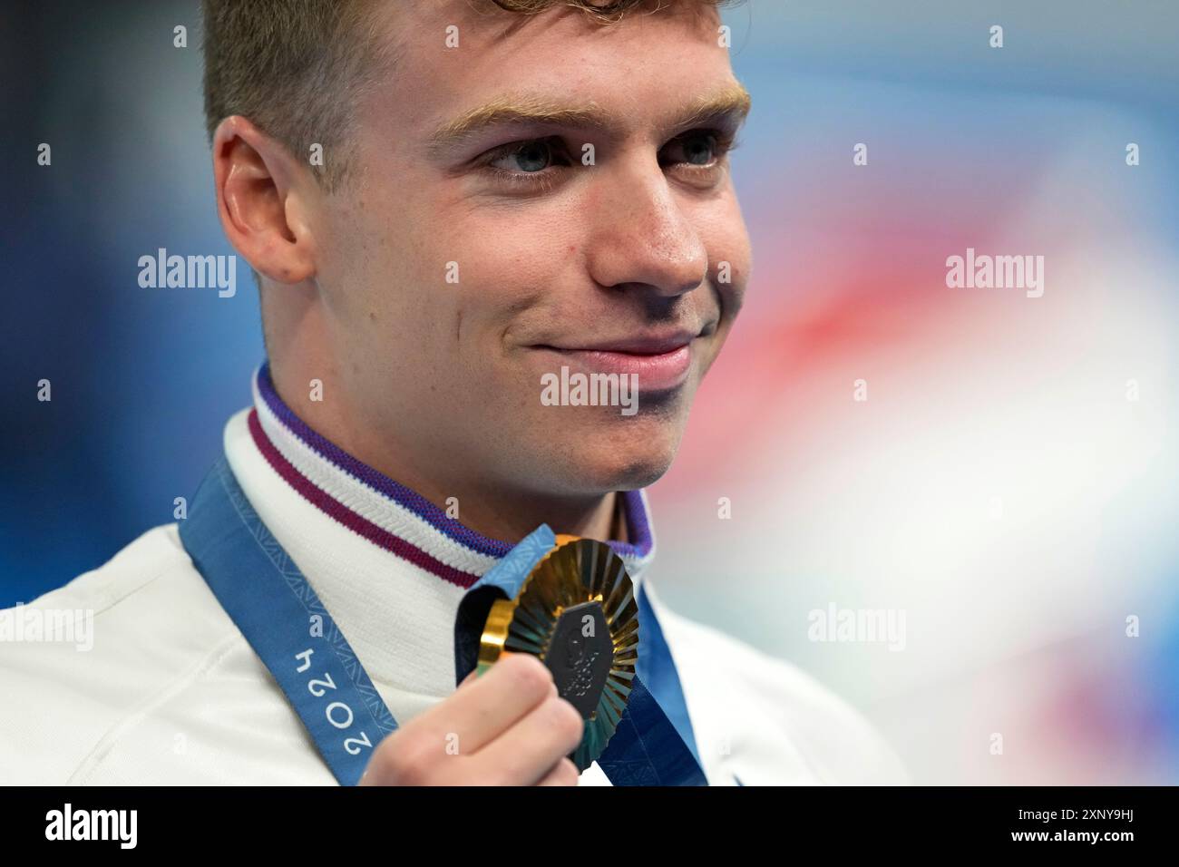 Leon Marchand of France, poses with his gold medal for the men's 200 ...