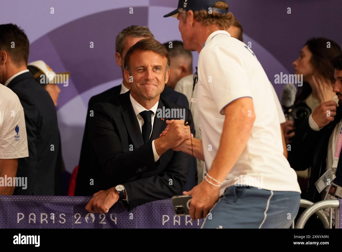 French President Emmanuel Macron congratulates a team staffer during a ...