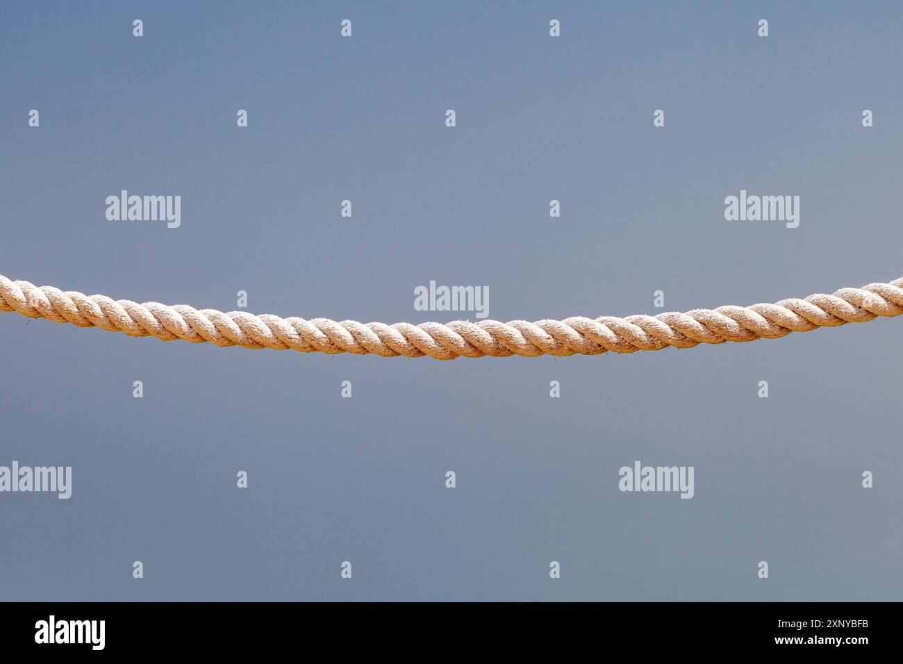 curved sea rope hanging on blue sky background Stock Photo - Alamy