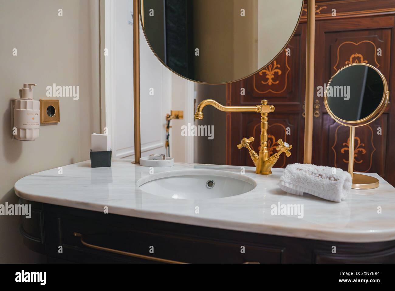Luxurious Bathroom with Marble Countertop and Gold Fixtures in a High ...