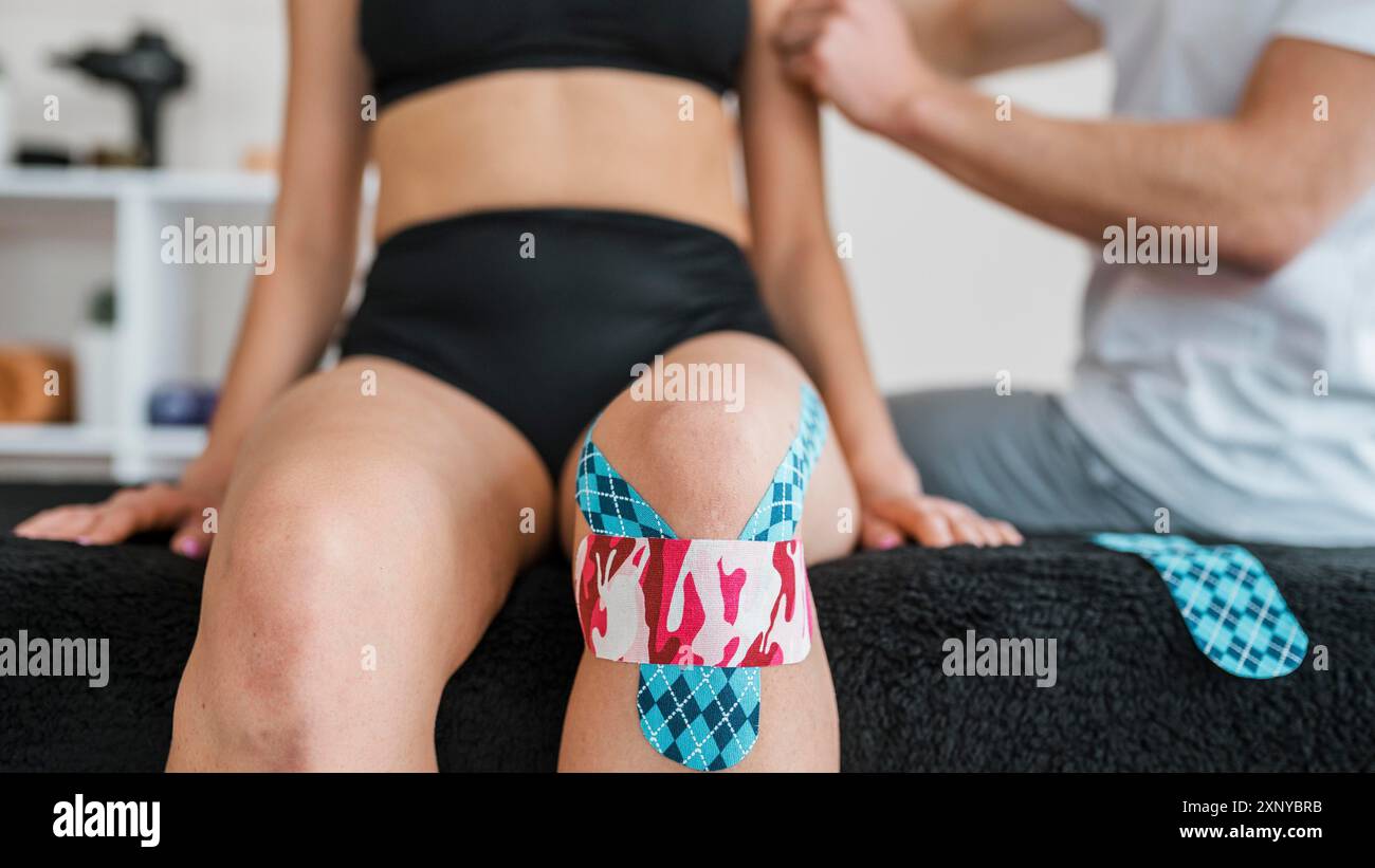 Female patient physiotherapy with knee brace tape Stock Photo - Alamy