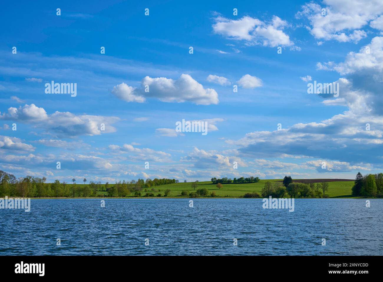 Ober Moosersee surrounded by green fields and trees under a partly ...