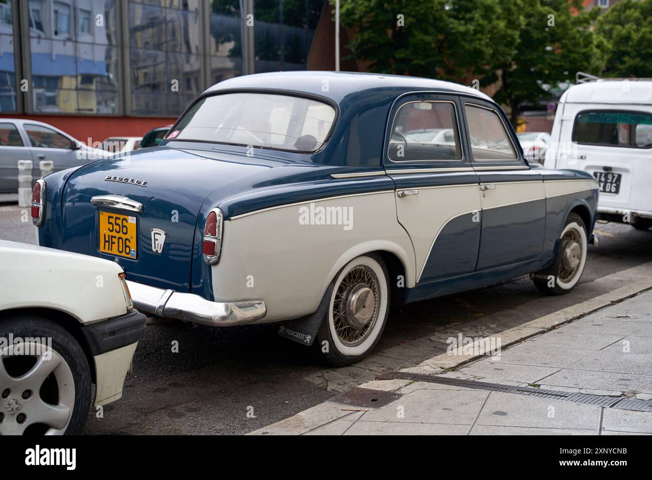 Rear side view of vintage blue and white Peugeot 403 car released circa ...