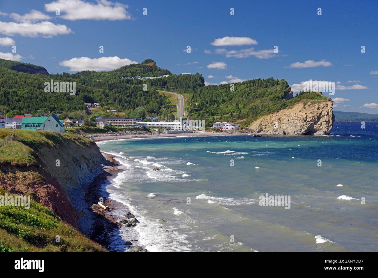 Coastal landscape with hills, cliffs and houses, the sea and waves ...