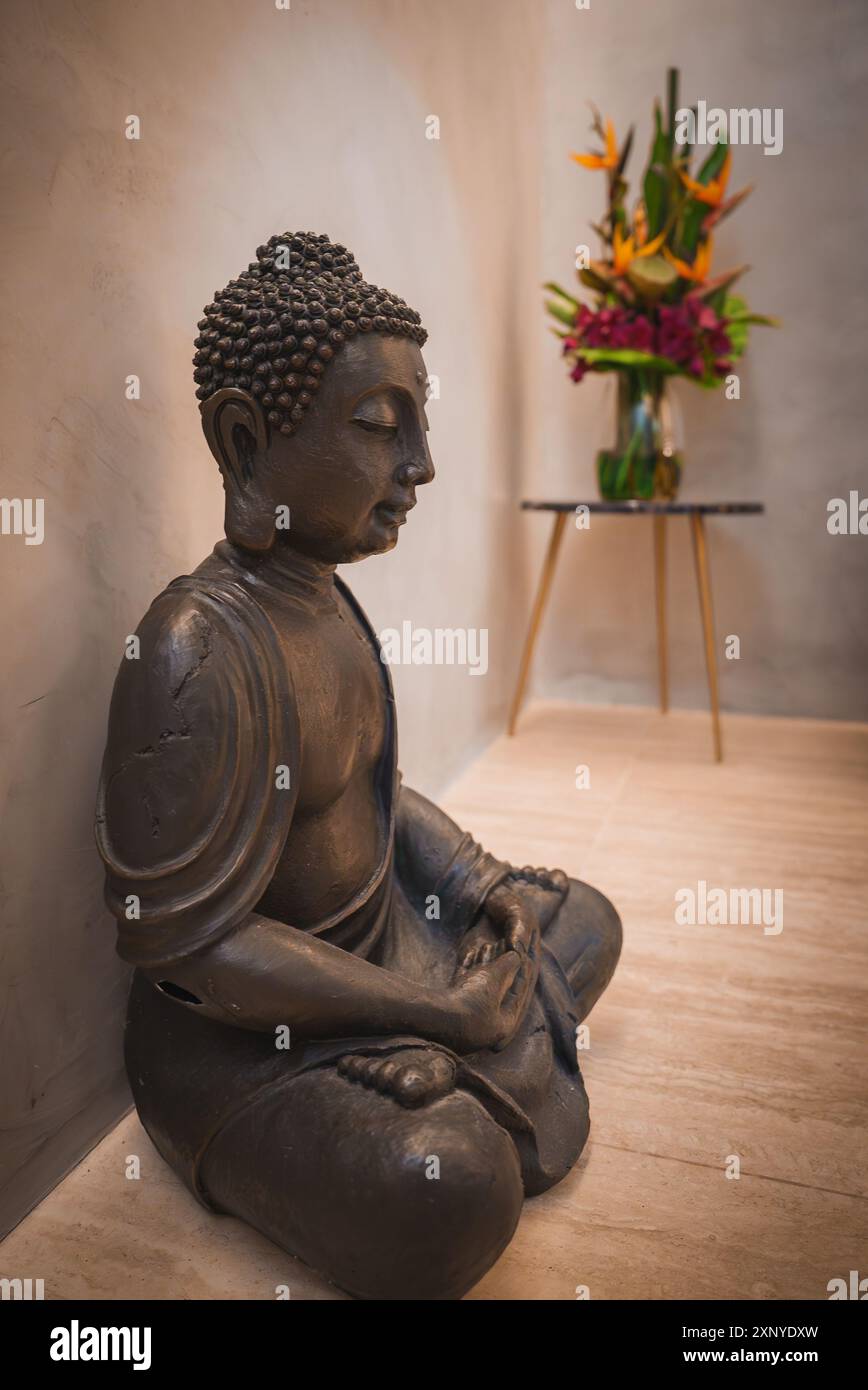 Serene Interior with Bronze Buddha Statue and Vibrant Floral ...