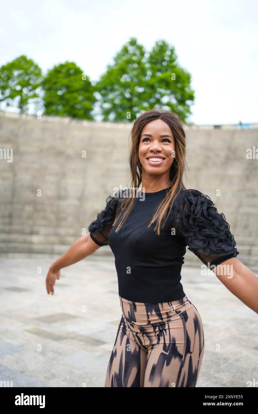 Vertical photo of a beauty hispanic smiling woman dancing salsa in a ...