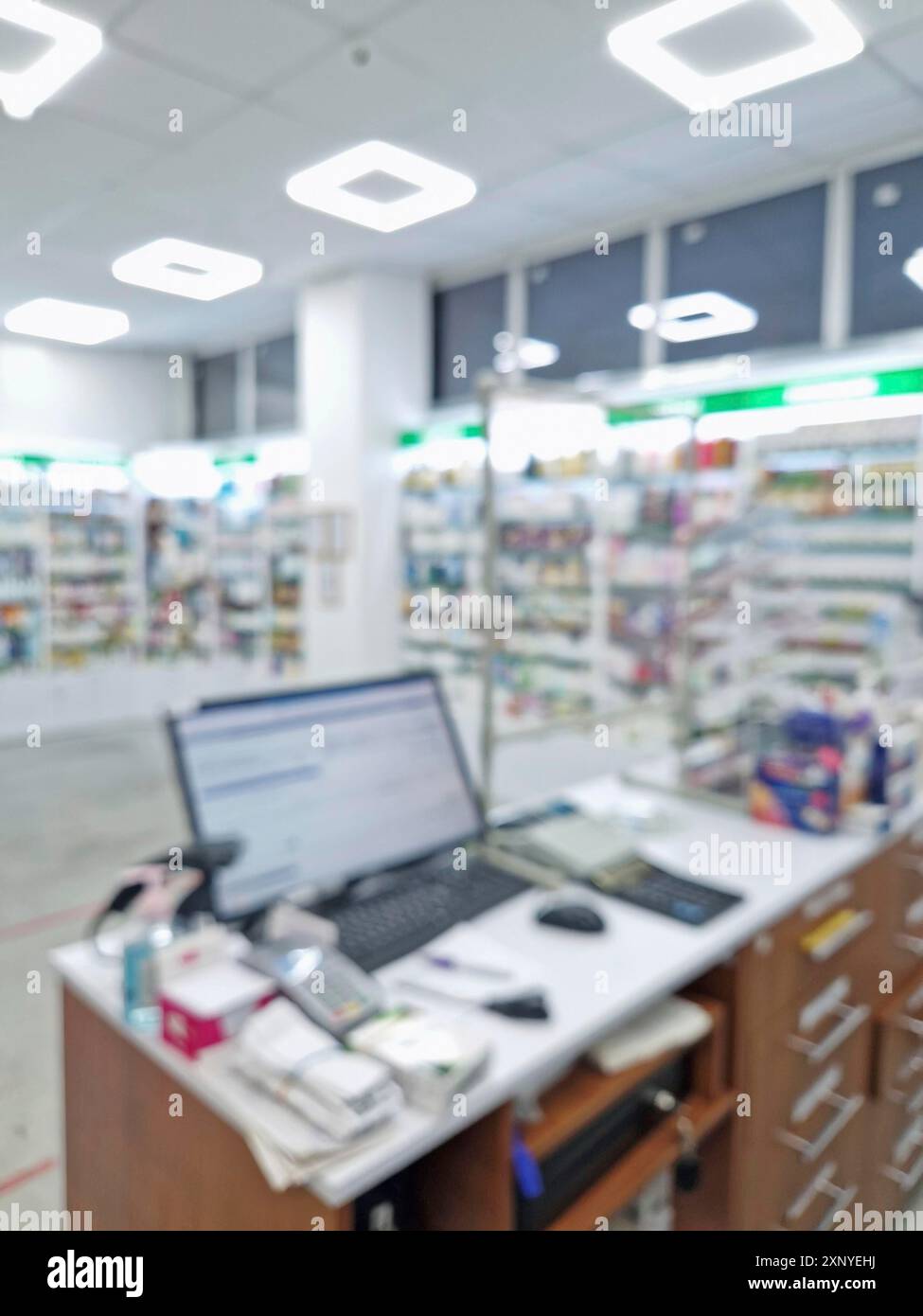 Blurred view inside of pharmacy with the seller counter, computer and ...