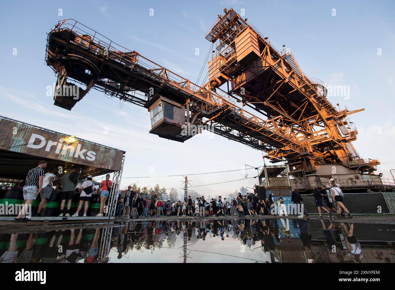 An open-cast mining excavator is reflected in a puddle at the Melt ...