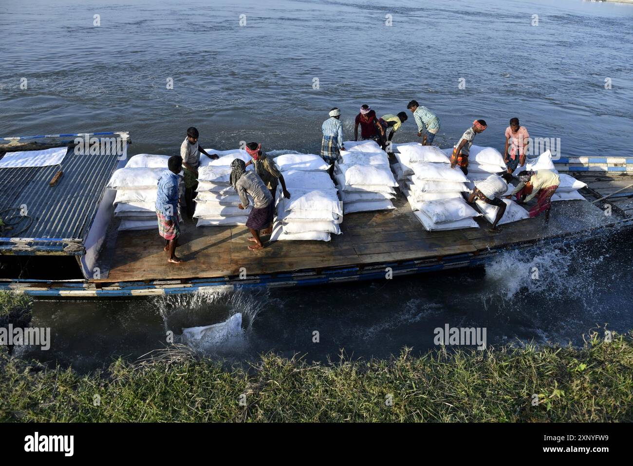 Public Works Department (PWD) of Assam labourer throwing sand bag from ...