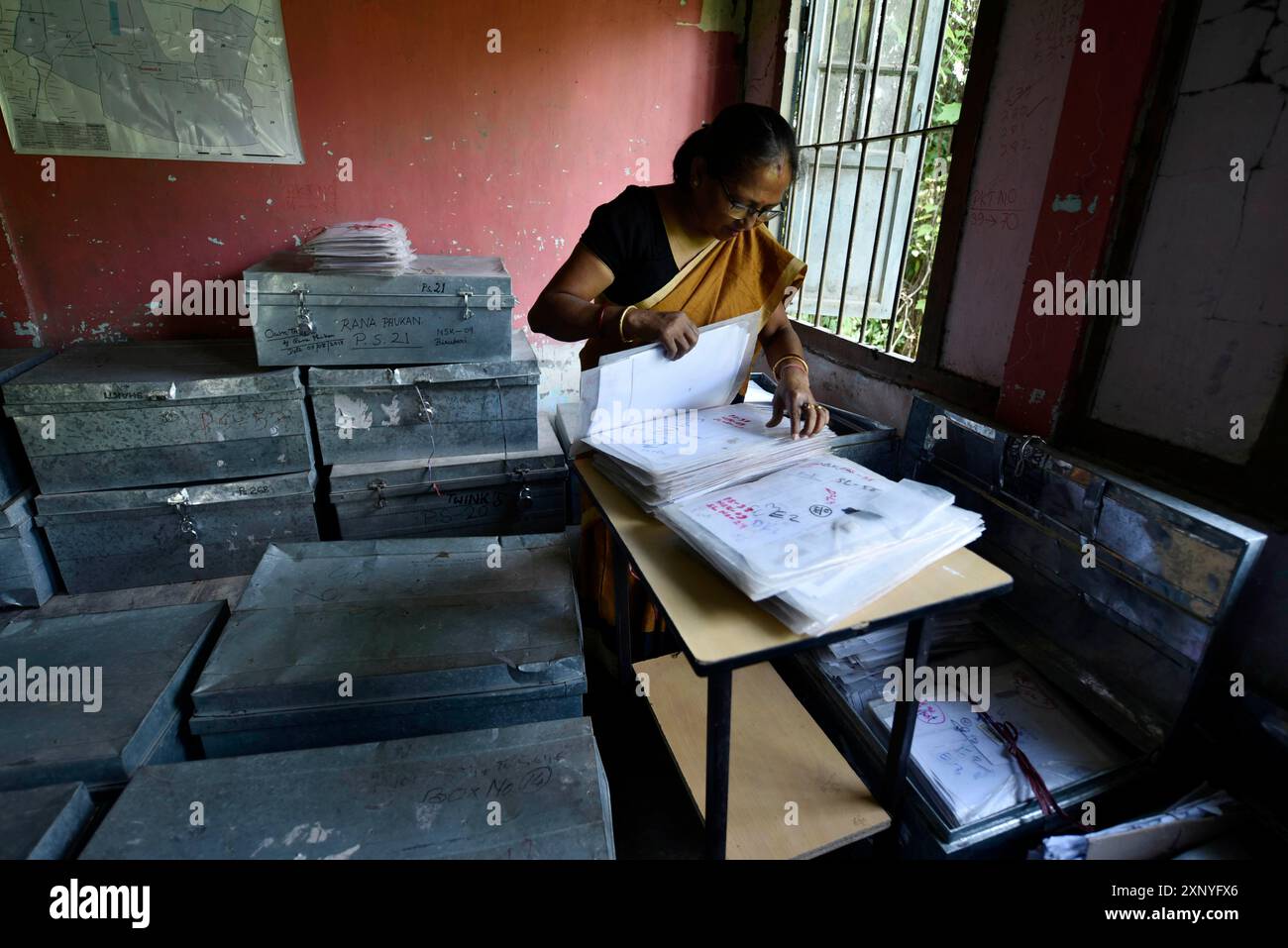 An official checks the documents submitted by people at an National ...