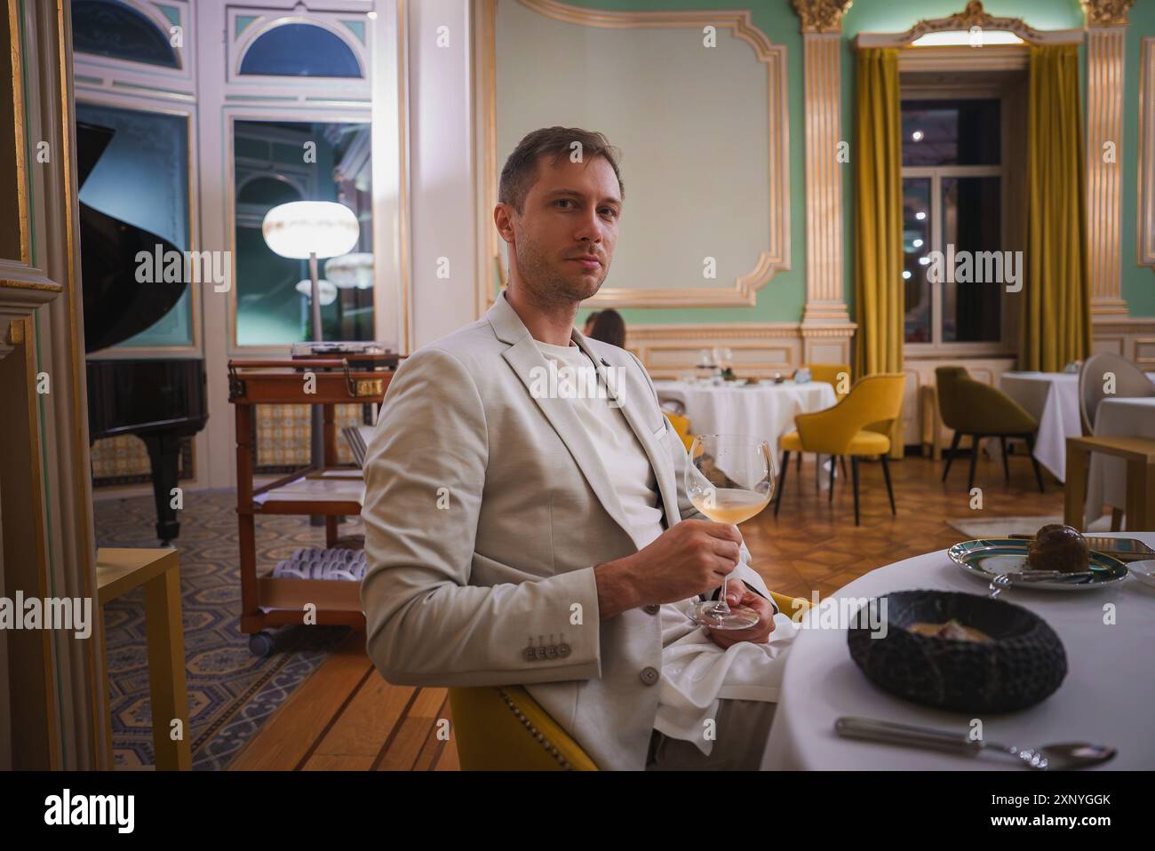 Man Enjoying Fine Dining in Luxurious Hotel Restaurant with Grand Piano ...