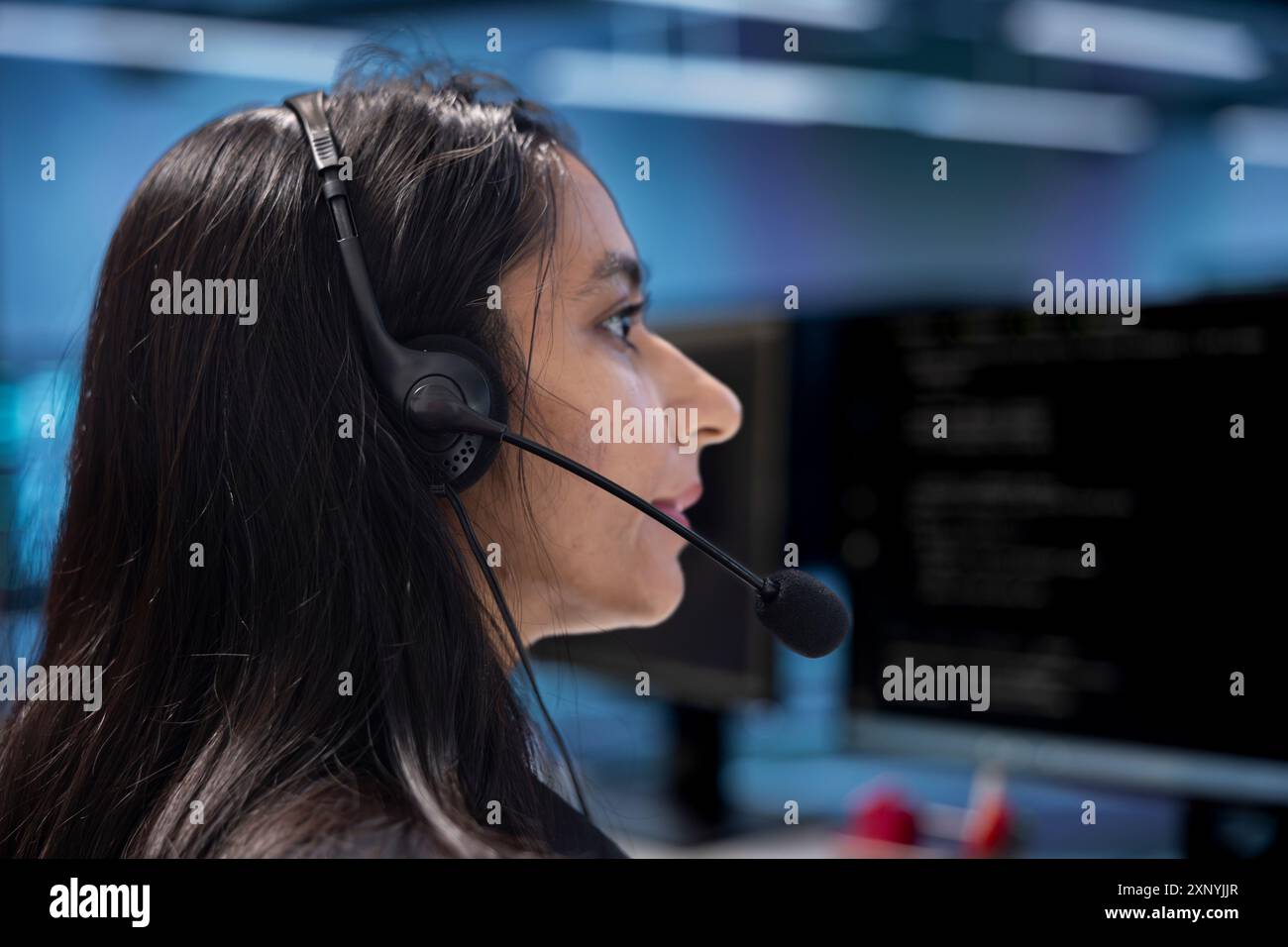 Admin in data center facility managing call center tasks, speaking into ...