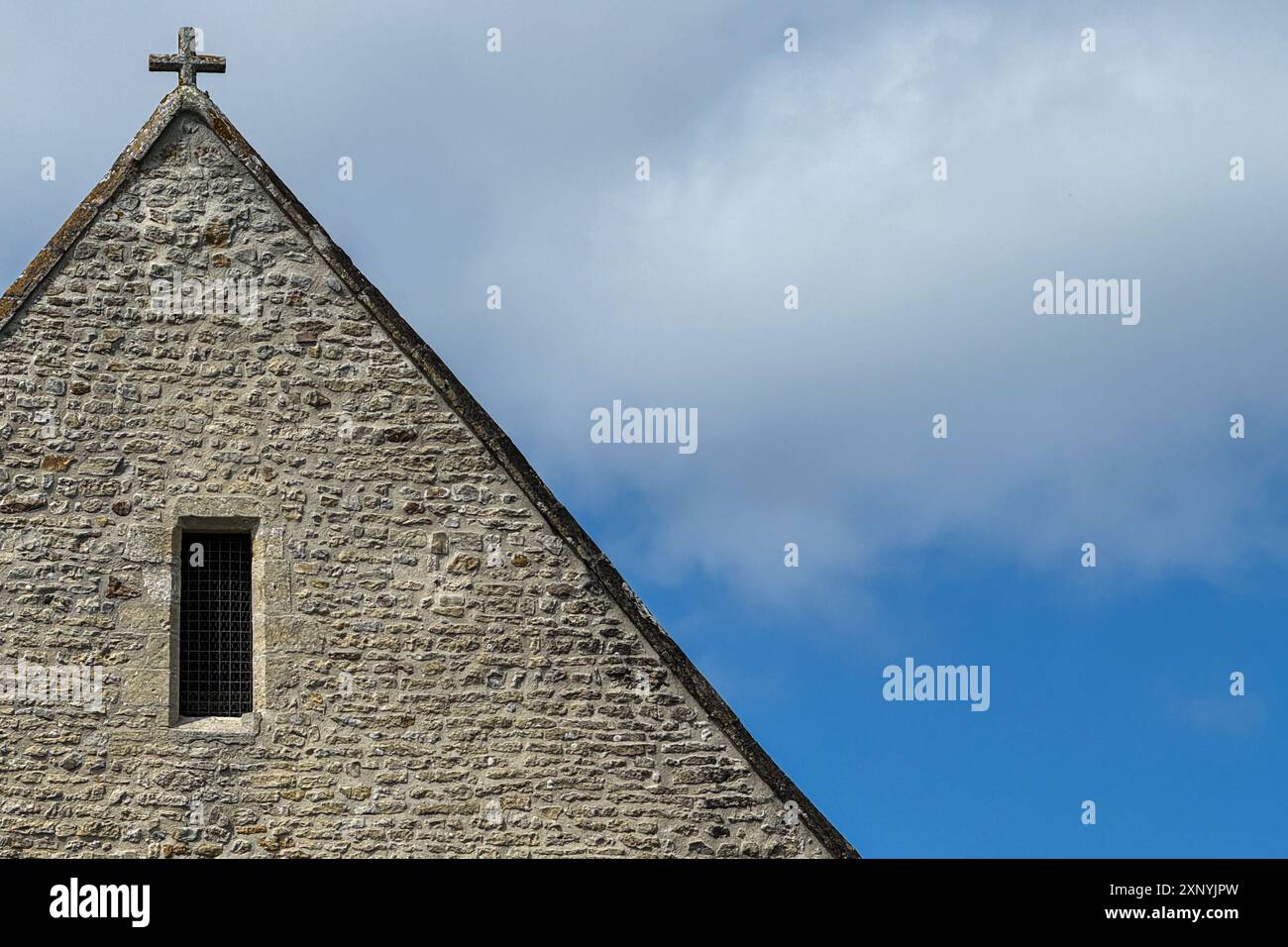 Still life shows an ancient, medieval stone building with a small cross ...