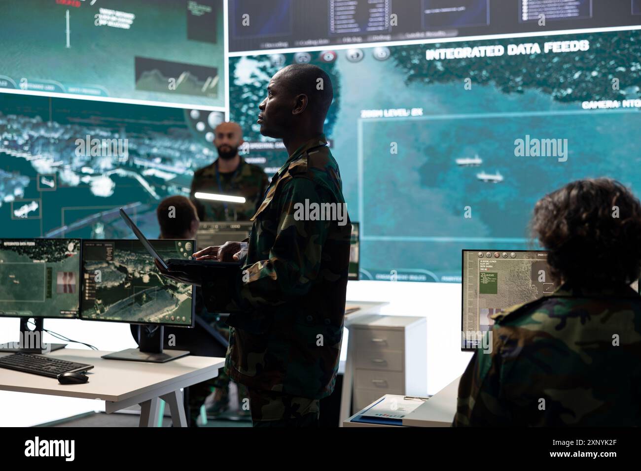 Intelligence analyst comparing satellite surveillance data before transmitting battlefield ...