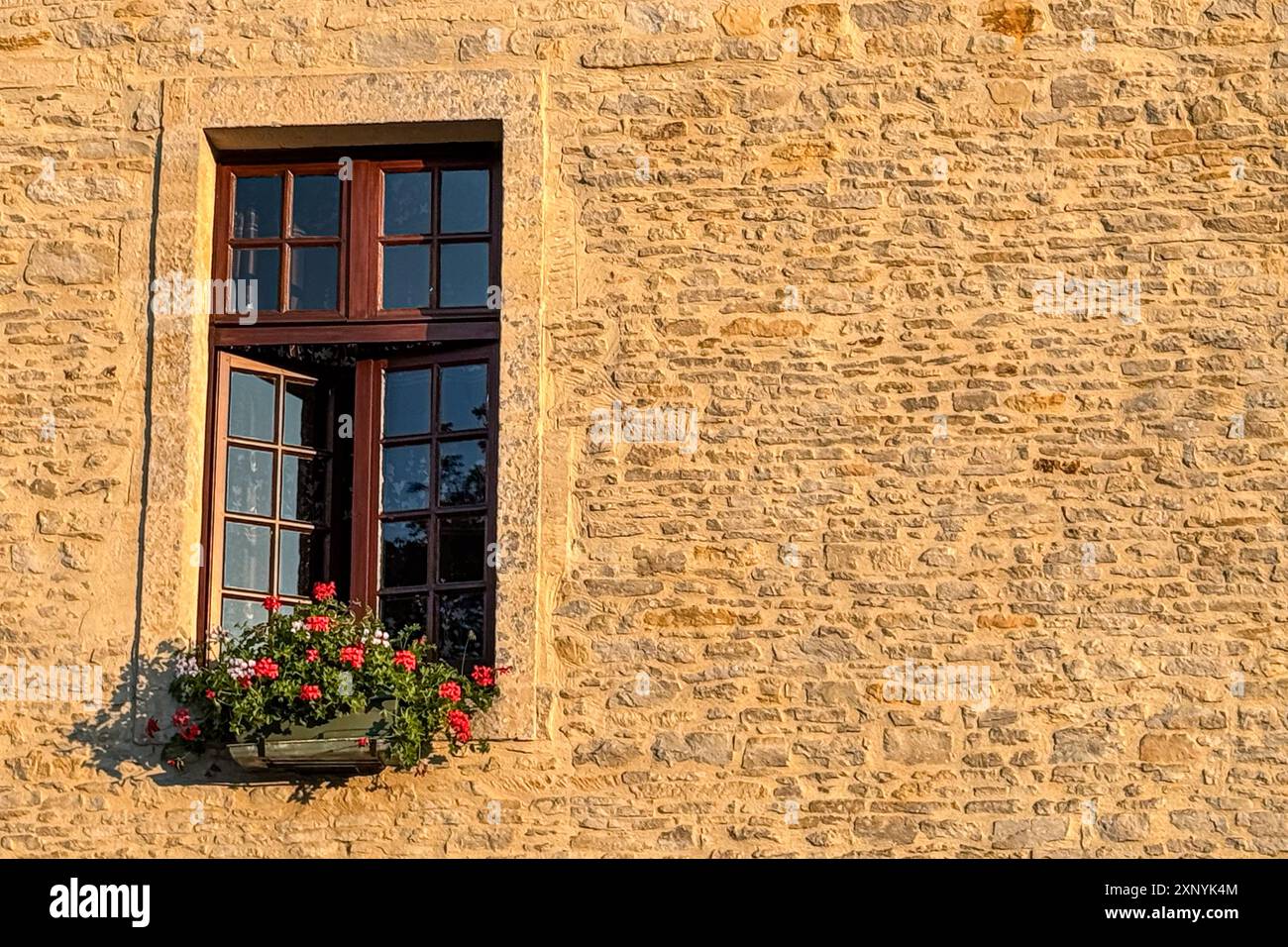 Still life shows a flower basket hanging outside a chateau window ...
