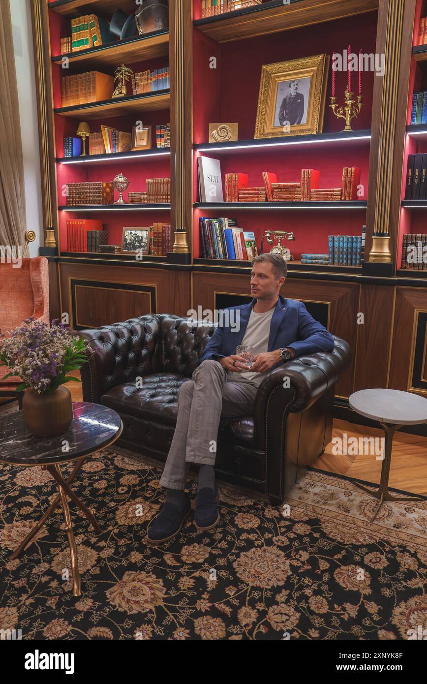 Luxurious Hotel Lounge with Man on Chesterfield Sofa and Elegant ...