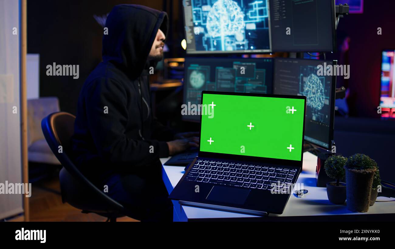 Isolated screen laptop used by cybercriminal in underground hideout to write lines of code and ...