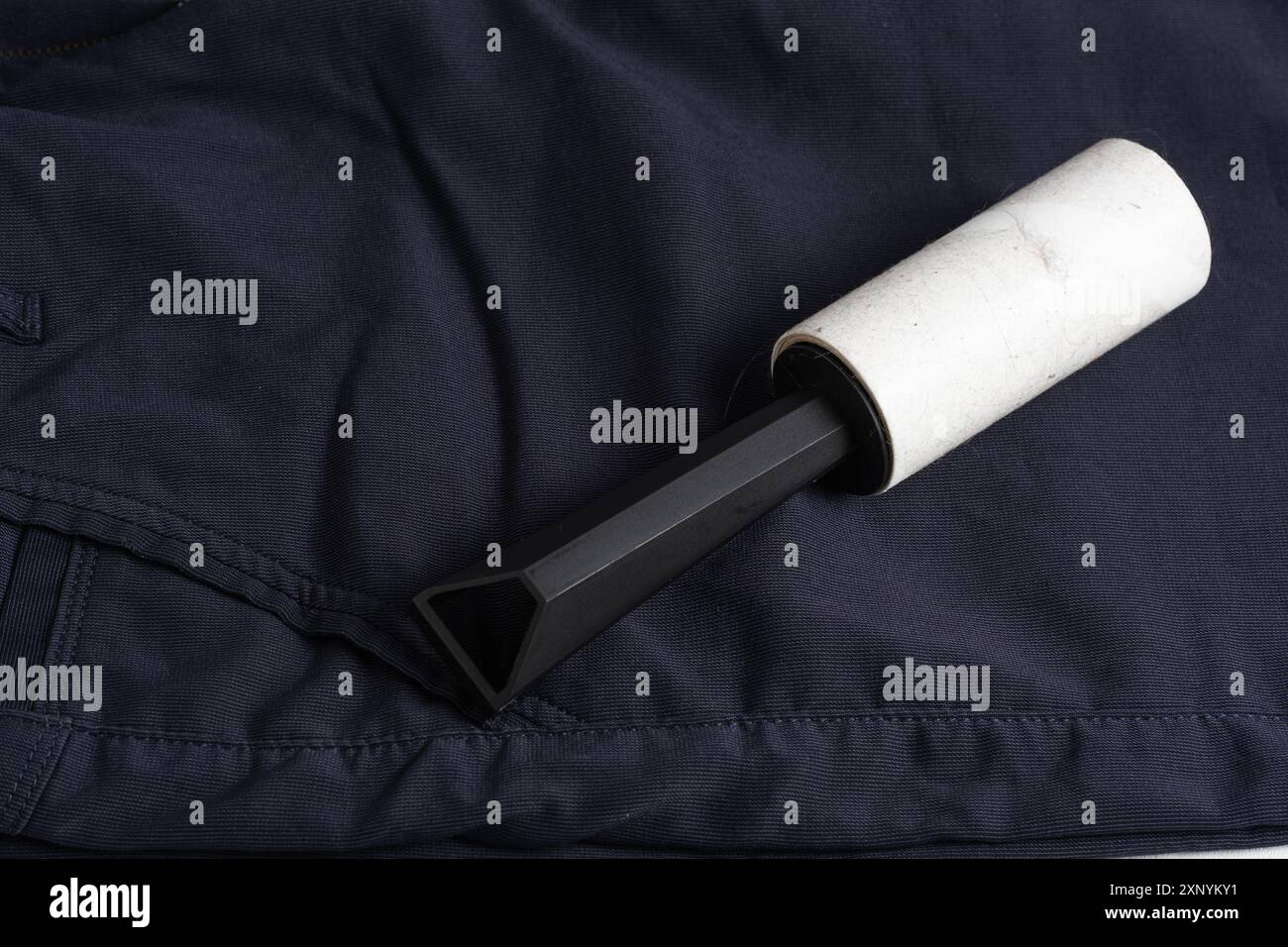 Roller for cleaning clothes on dark fabric background, closeup Stock ...