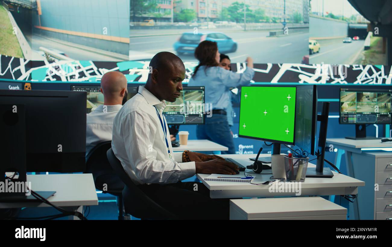 African american employee using greenscreen display and CCTV real time ...