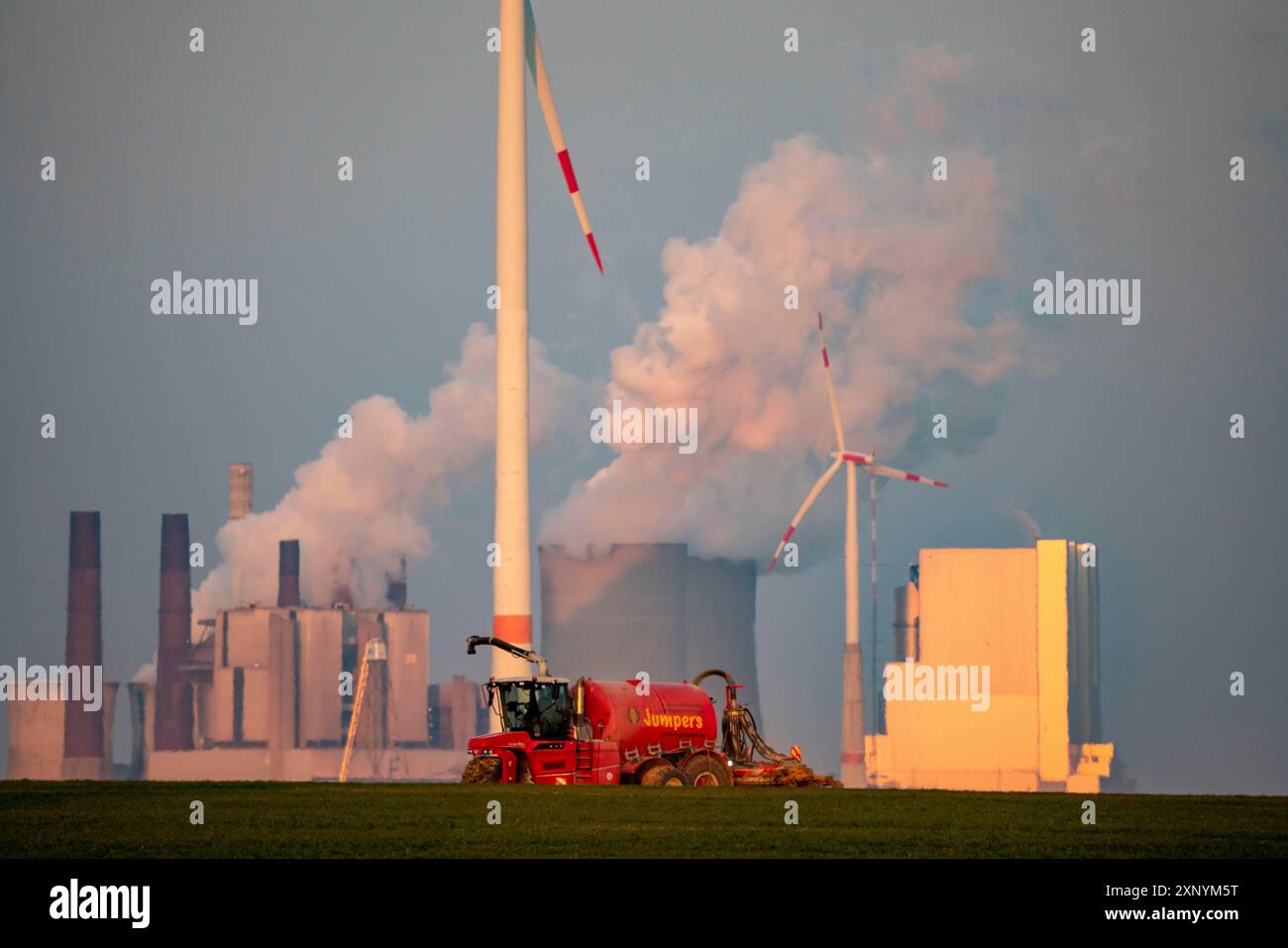 Tractor working a field in spring, spreading fermentation residue ...