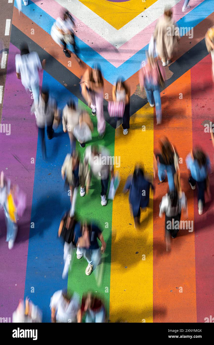 People crossing a pedestrian crossing, on a road, the road surface is ...