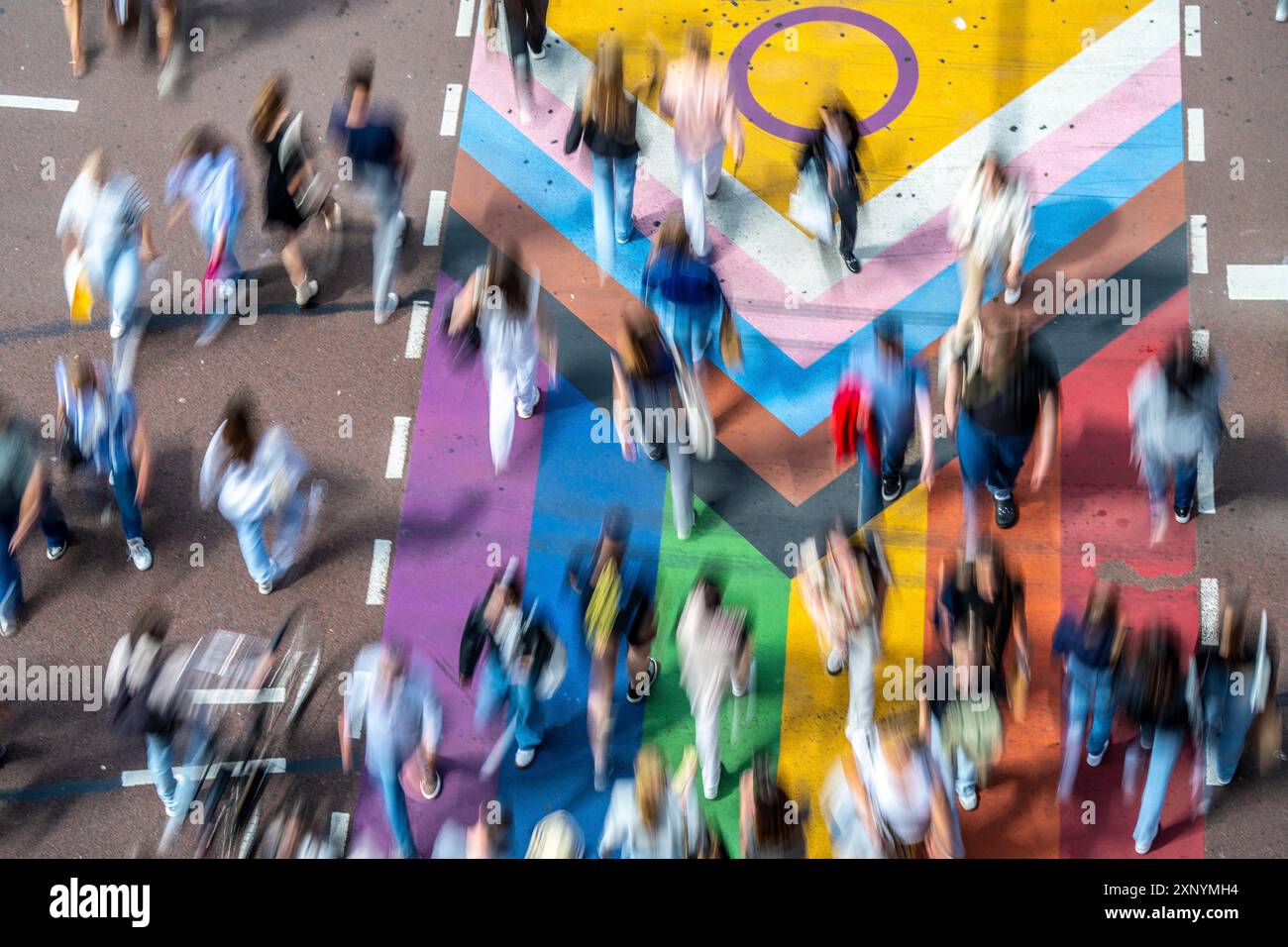 People crossing a pedestrian crossing, on a road, the road surface is ...