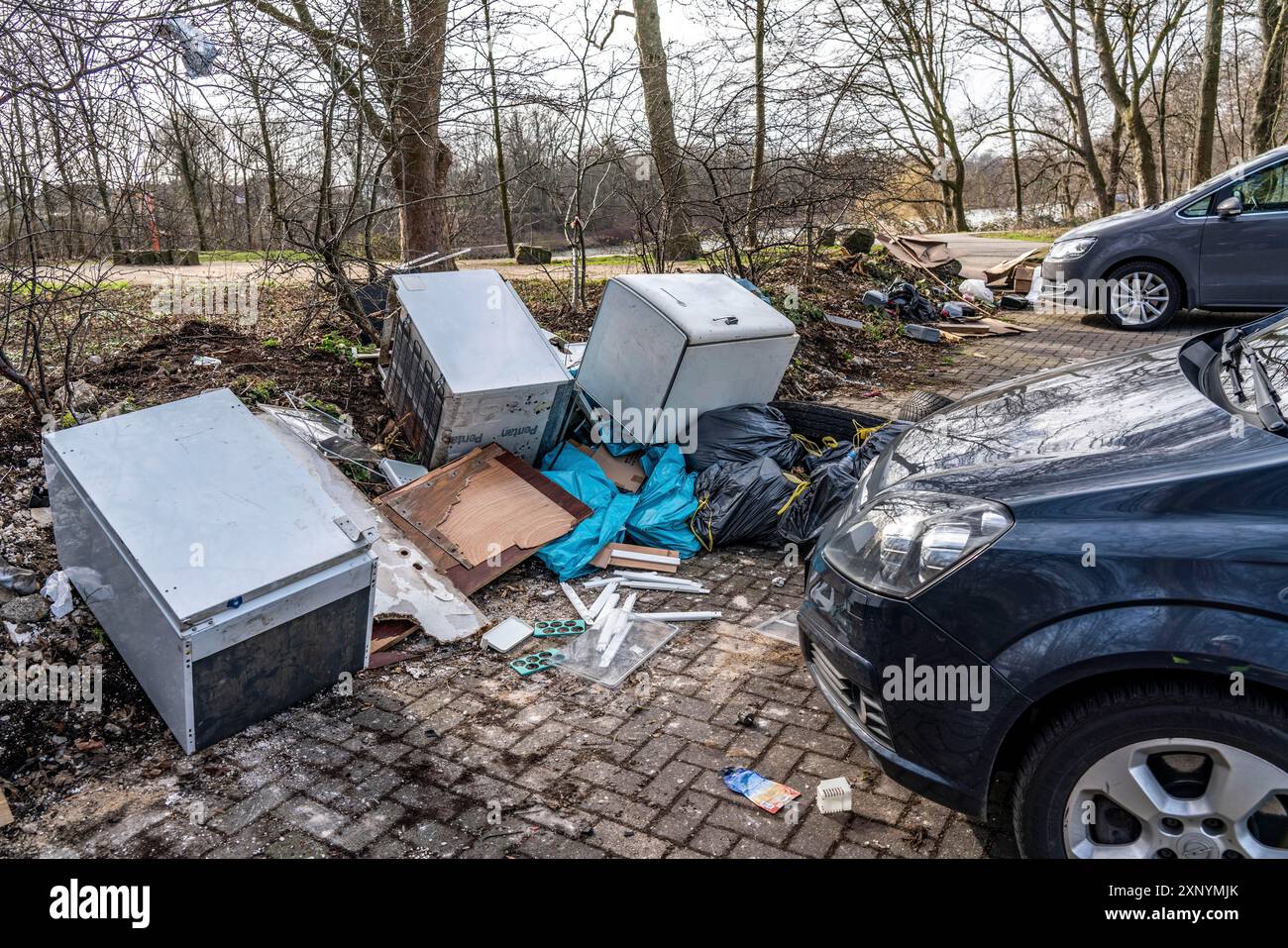 Illegal waste disposal in a car park, in a wooded area, tyres ...