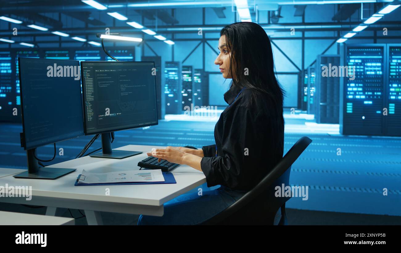 System administrator at PC desk working in computer network security data center, ensuring ...
