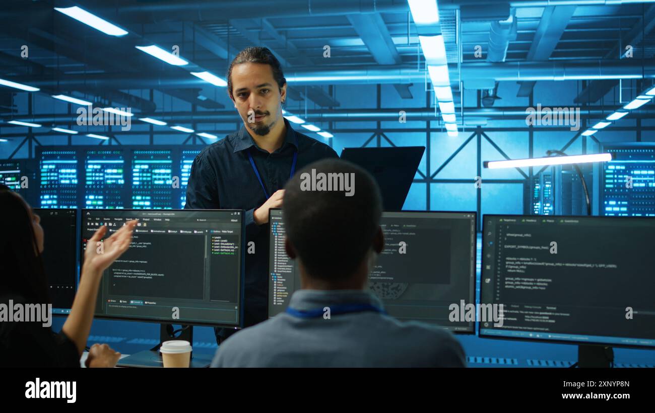 Manager supervising multiethnic team working in data center ensuring ...