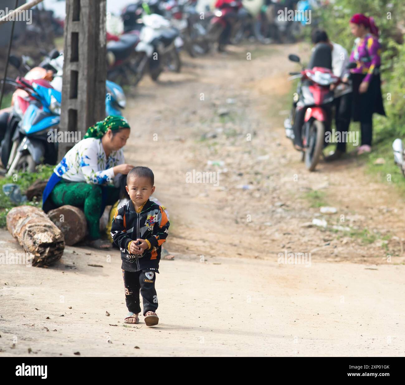 Little boy from the Hmong minority in badman jacket walking on a slope ...
