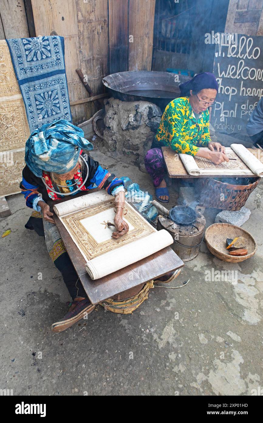 Vietnamese woman from the Hmong minority draw patterns on linen fabric ...