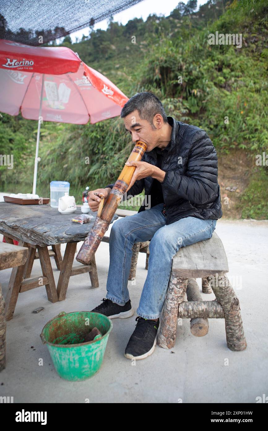 Vietnamese man smoking a thick bamboo pipe, Ha Giang province, Vietnam ...
