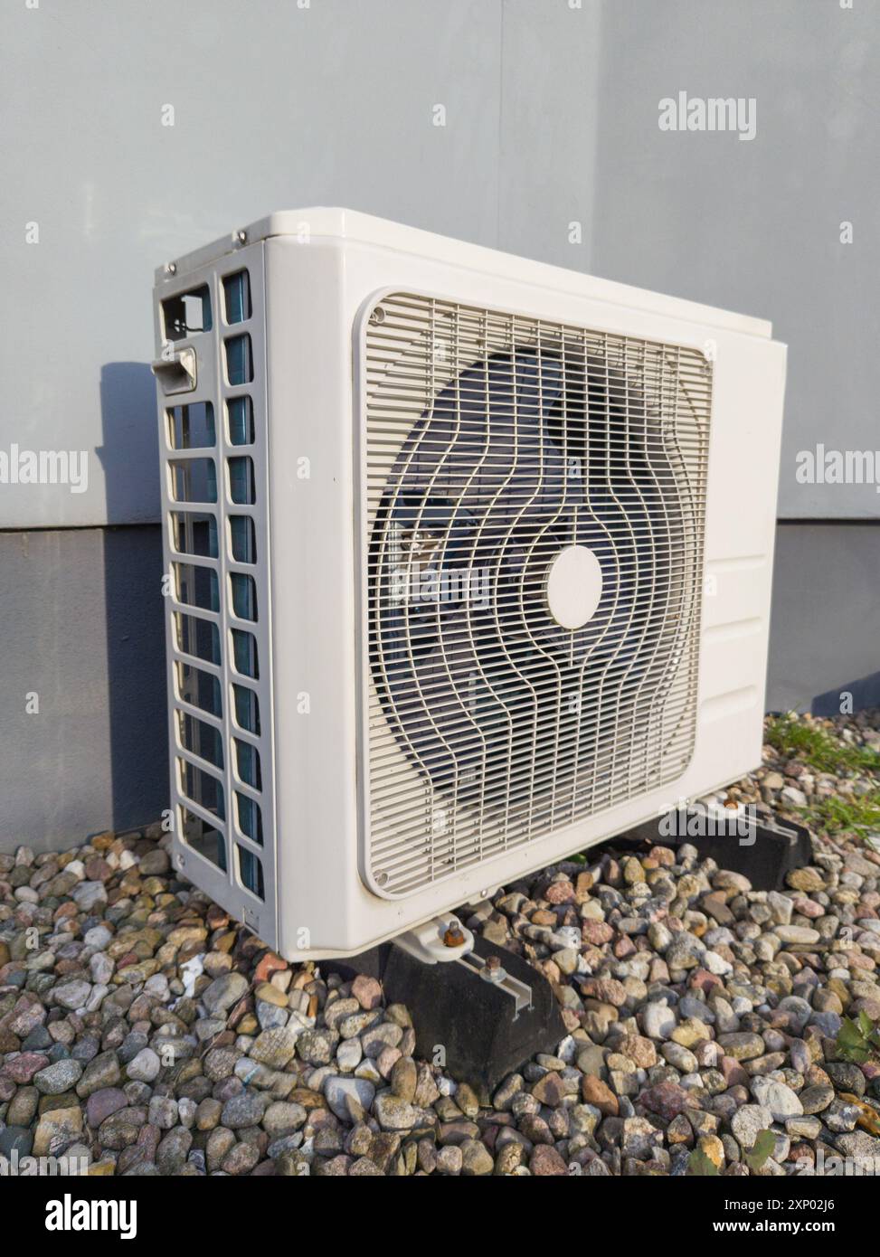 White Air Conditioning Unit on Pebbled Ground Stock Photo - Alamy