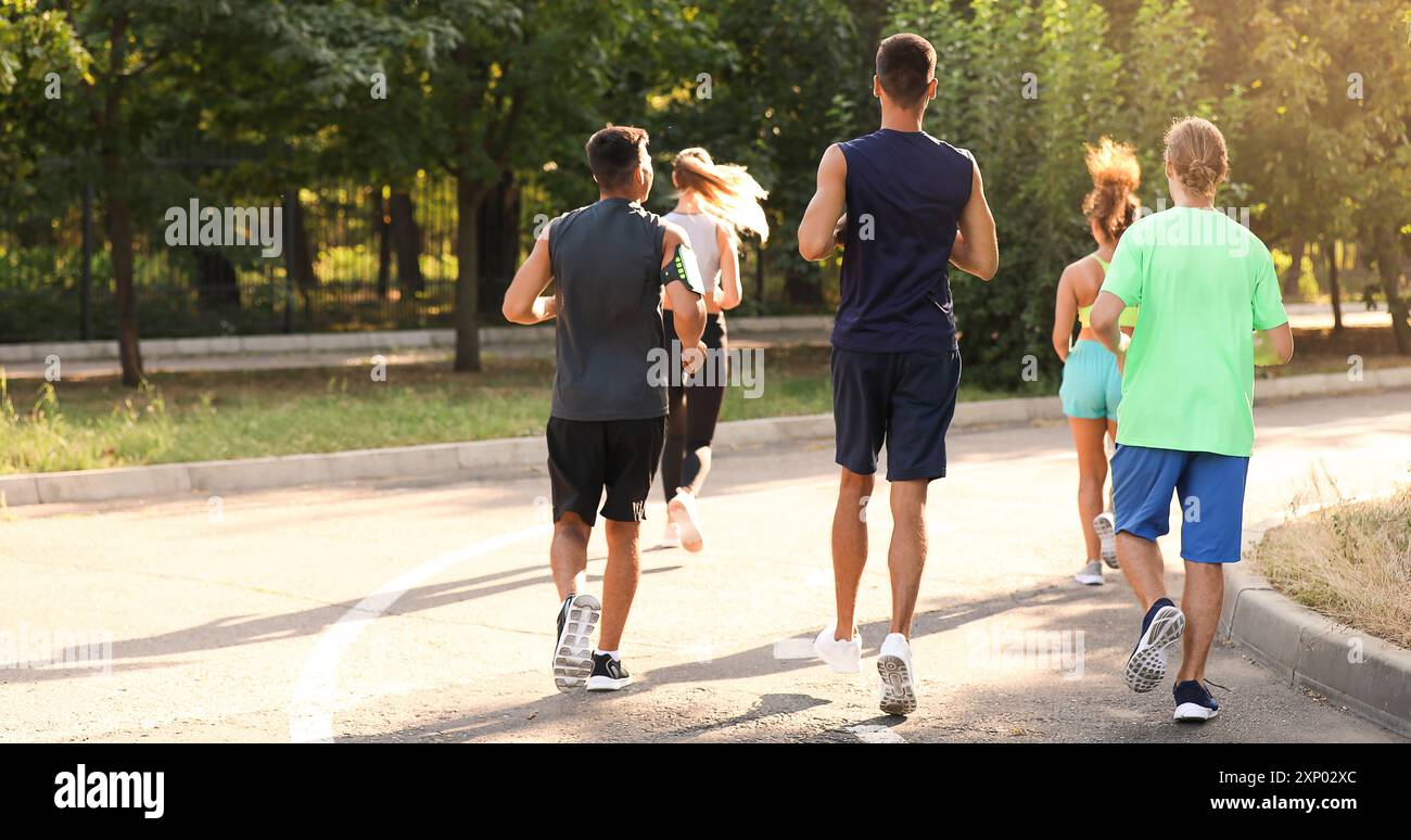 Group of sporty young people running outdoors, back view Stock Photo ...