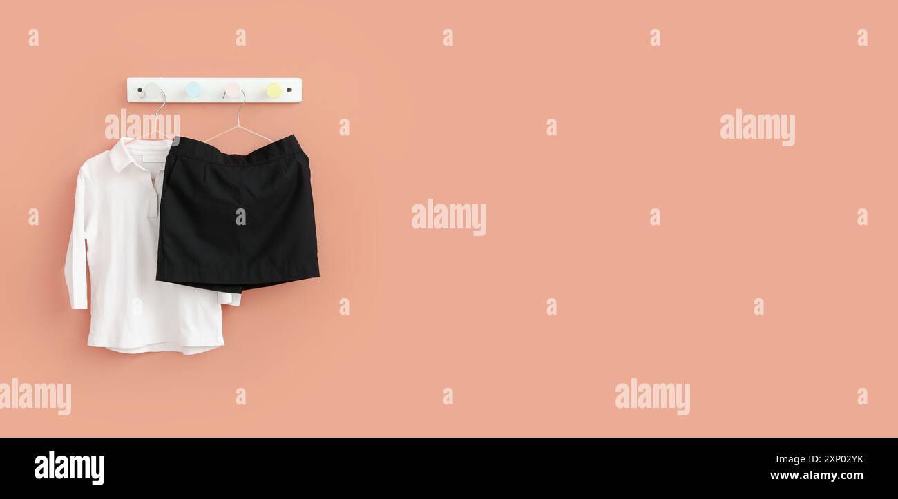 Stylish school uniform hanging on orange wall. Banner for design Stock ...
